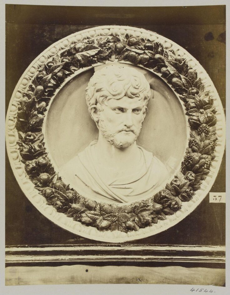 Circular bas-relief white portrait bust on blue ground surrounded by a ...