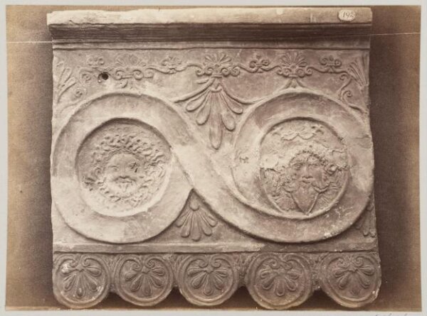 Bas-relief portion of a frieze of scrollwork with masks in terra cotta ...