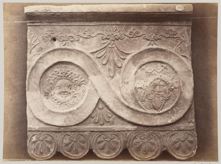 Bas-relief portion of a frieze of scrollwork with masks in terra cotta ...